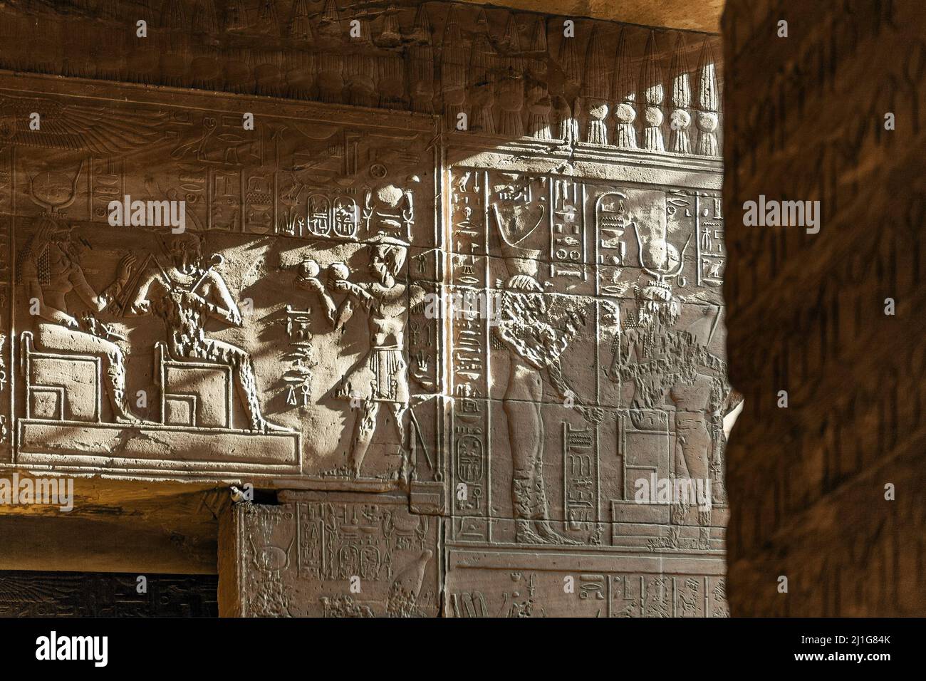 Bas relief carvings in a shaft of sunlight in the Temple of Isis at ...