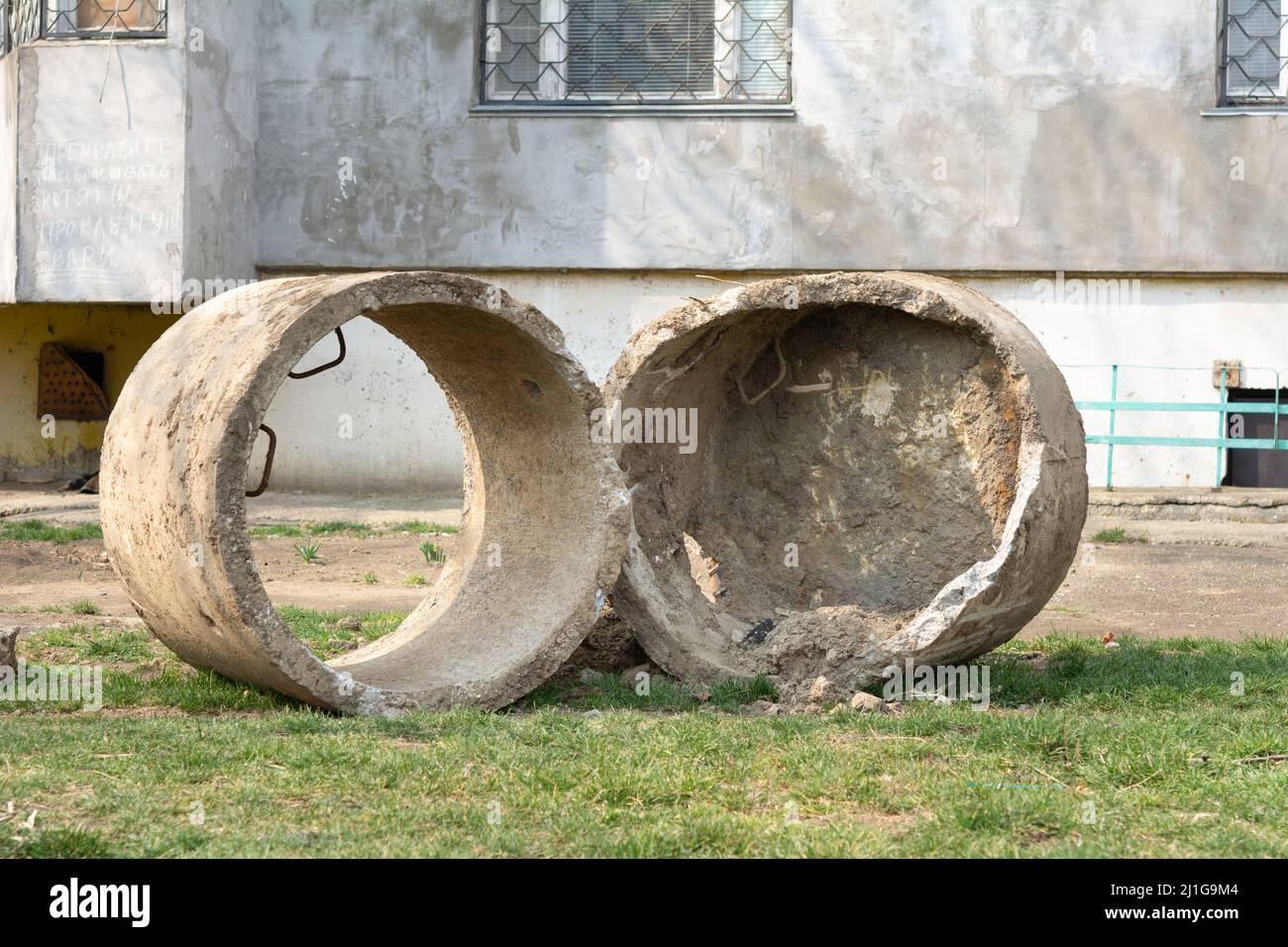 Sewer ring. Broken sewer ring covered with clay and sand on the lawn ...