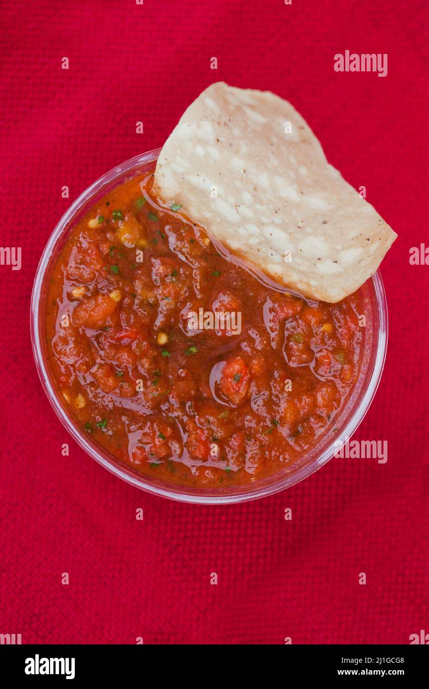An individual cup of Mexican Tex-mex salsa with a single flour tortilla ...