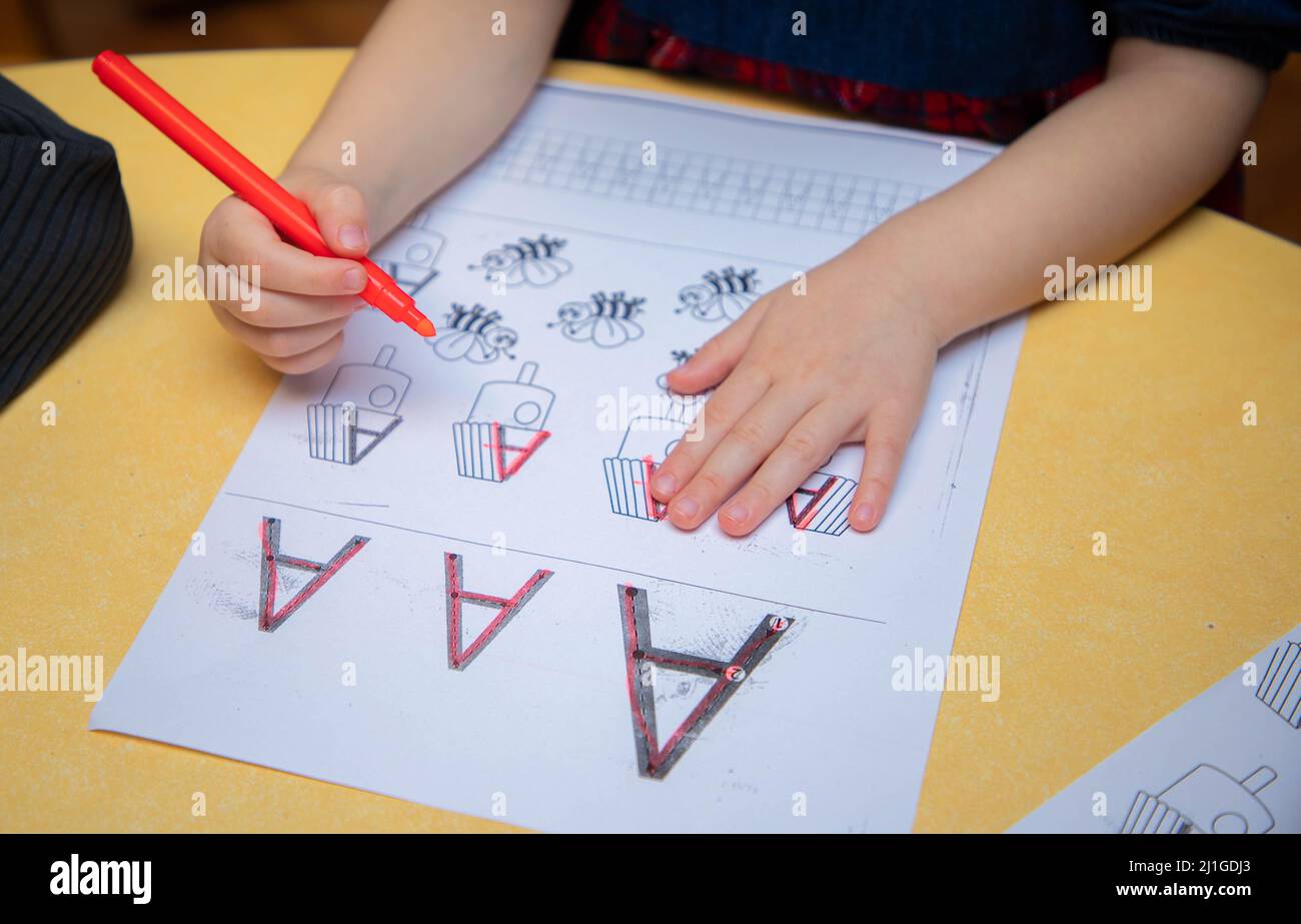 The hands of a child of European appearance write and circle the ...