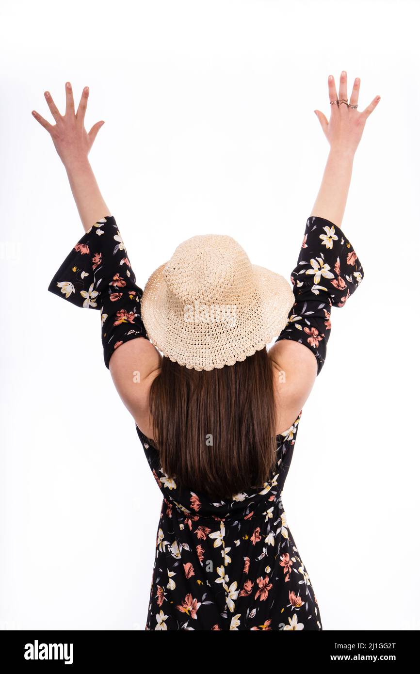 Young girl with raised arms. The girl is photographed from behind, she ...