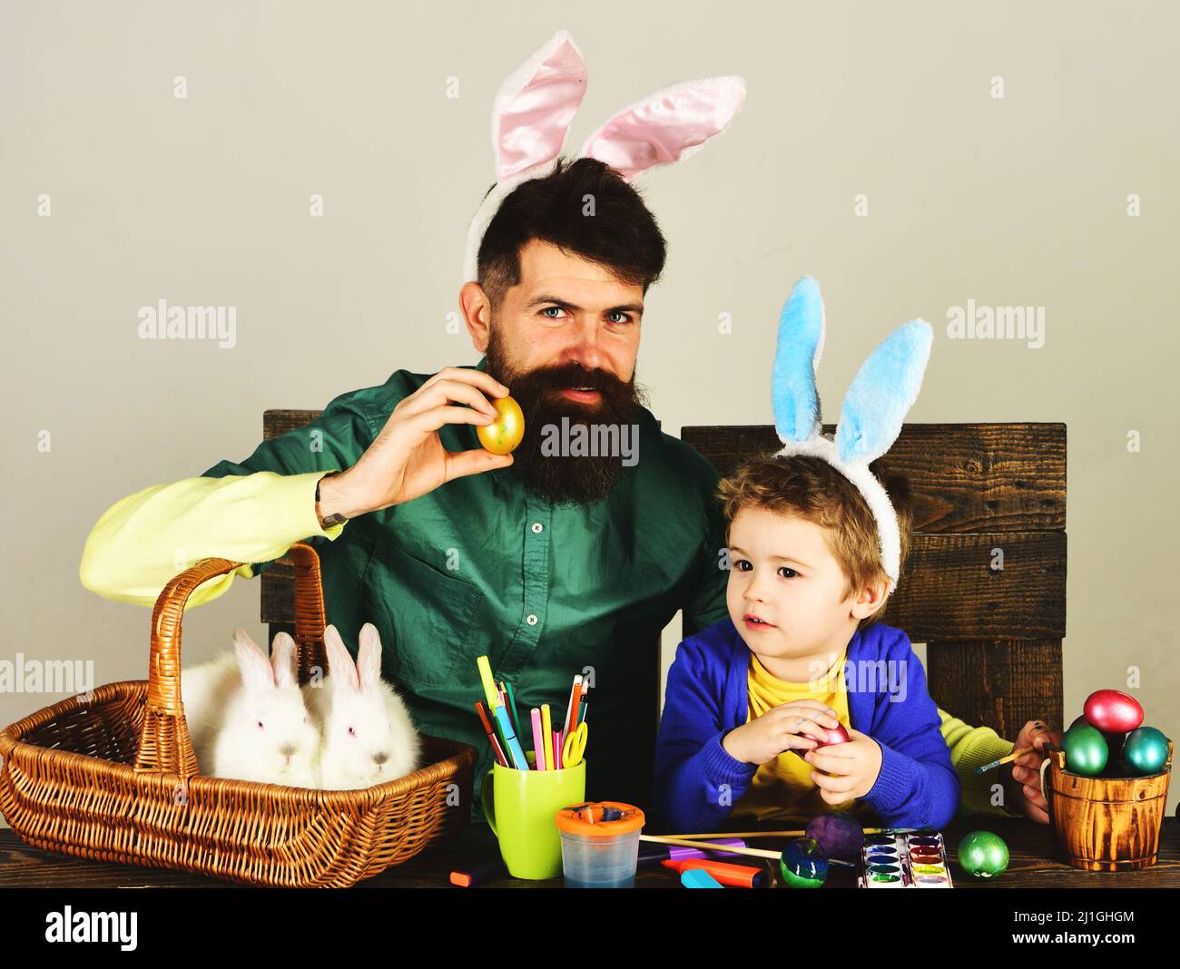 Happy family with painted Easter eggs. Father and son in bunny ears ...