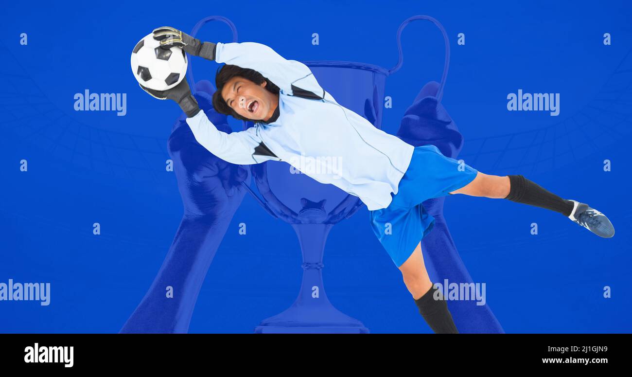 Caucasian goalkeeper holding soccer ball over hands holding winning ...