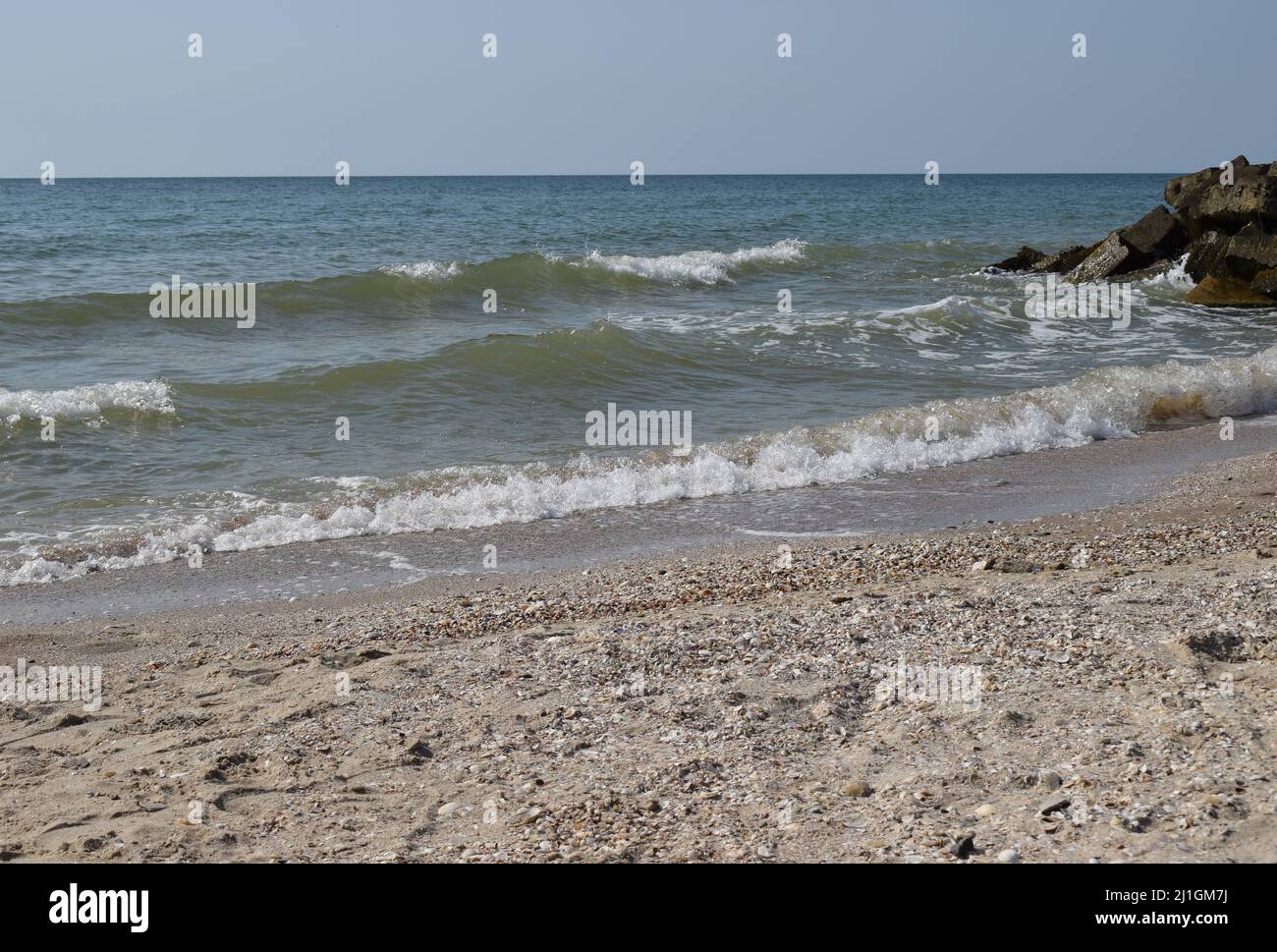 Rock fragments on a wild beach. The sky was clear and the waters of the ...