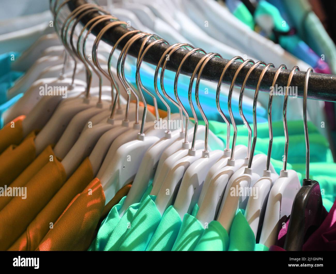 many coat hangers with hanging clothes for sale in the clothing stall ...