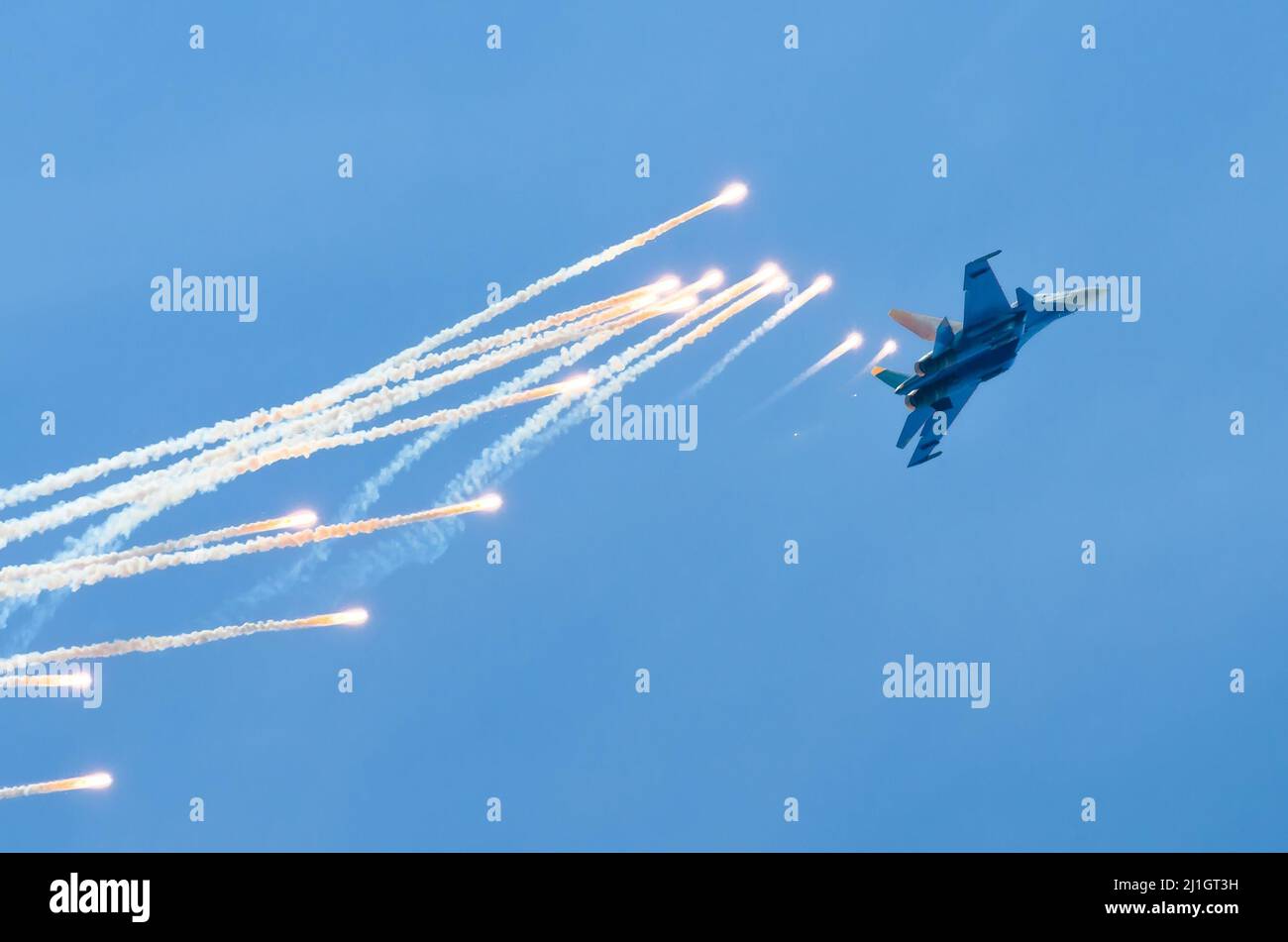 Aircraft fighter flies and shoots heat guns in the blue sky Stock Photo ...