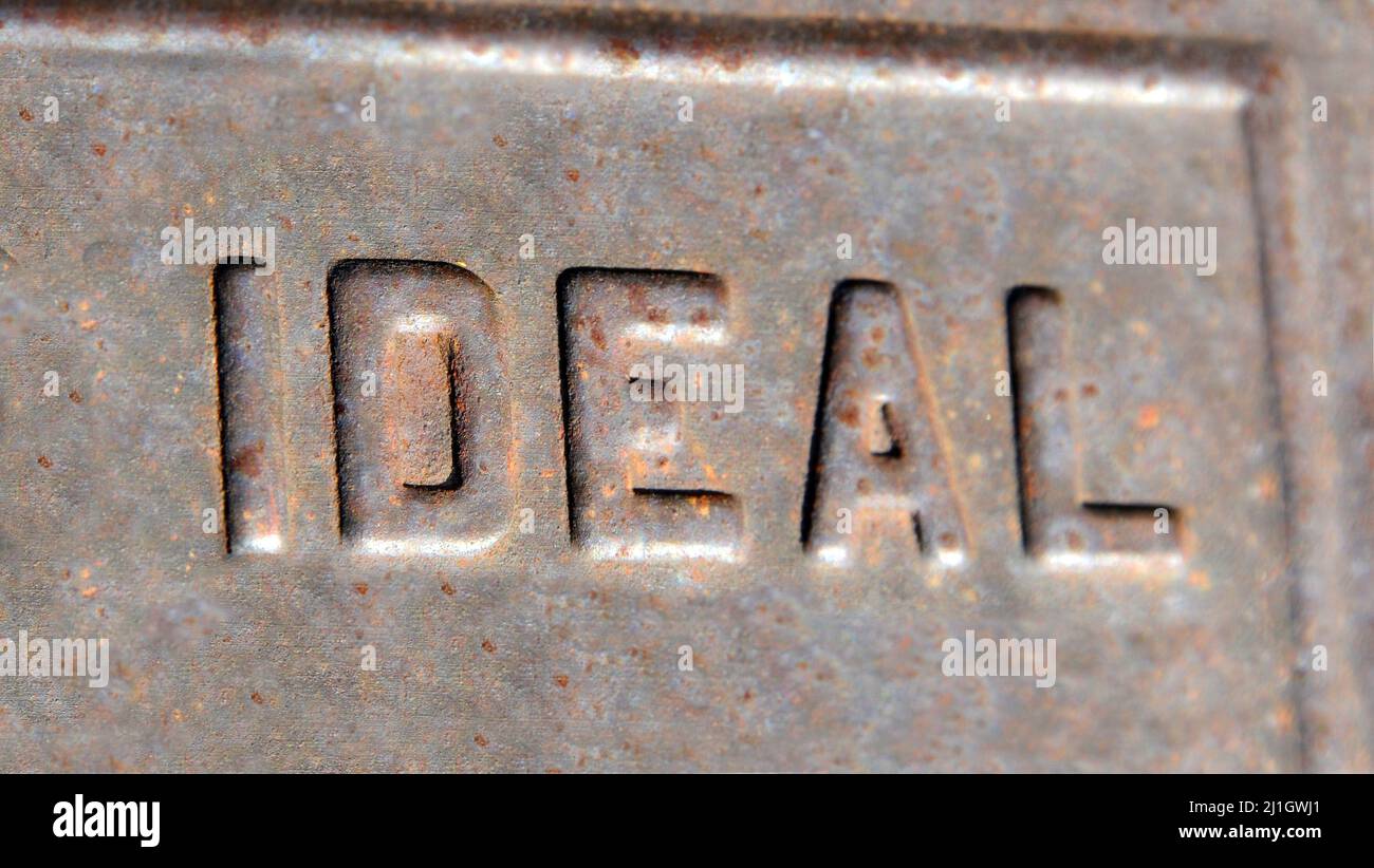 Letters spelling "Ideal," are weathered and old. Raised metal letters ...