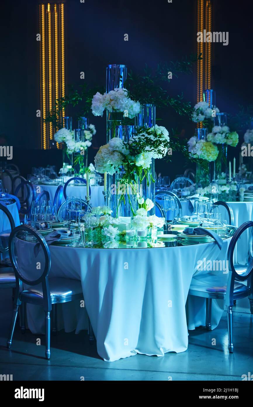 Table setup in blue light. Ready to event Stock Photo - Alamy