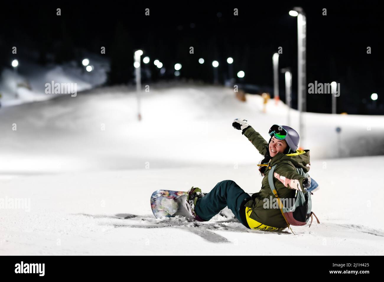 Snowboarder girl posing on slopes. Night skiing in winter resort Stock ...