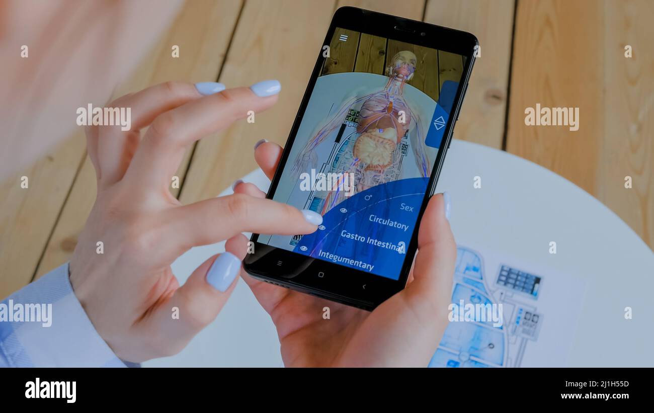 Woman using smartphone with augmented reality app: 3d model of human ...