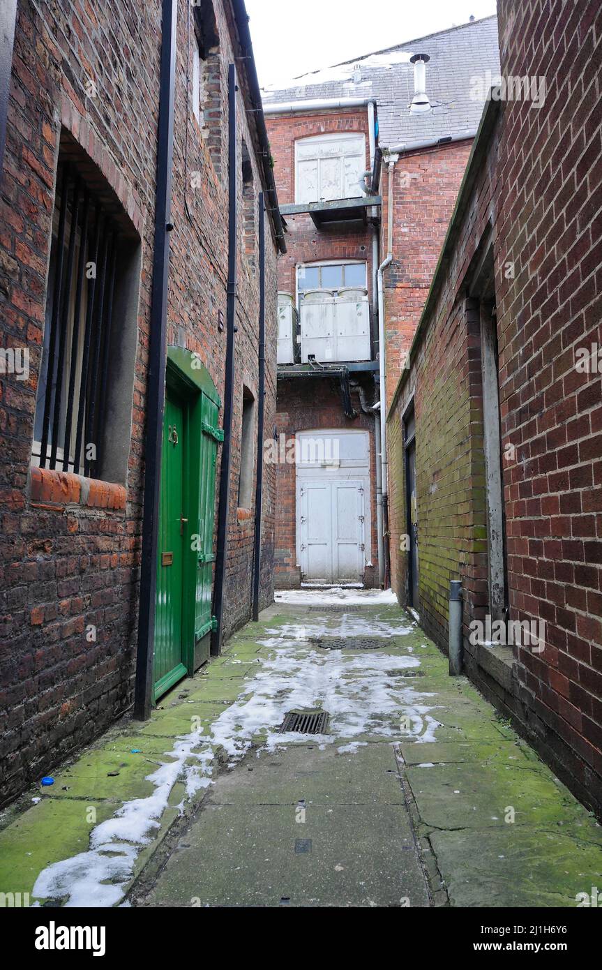 A cold and desolate alley with old red brick buildings in winter Stock ...