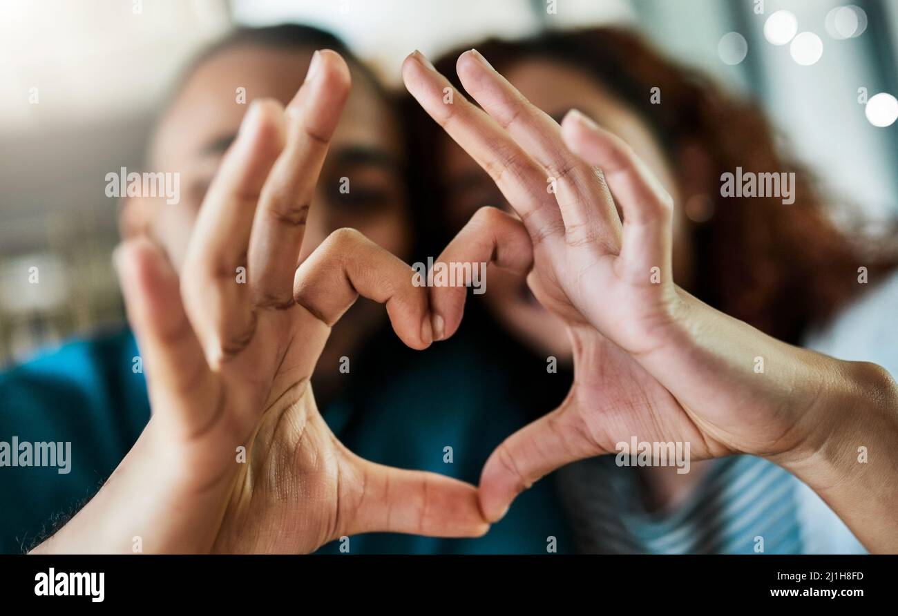 You complete me. Shot of a young couple making a heart gesture with ...