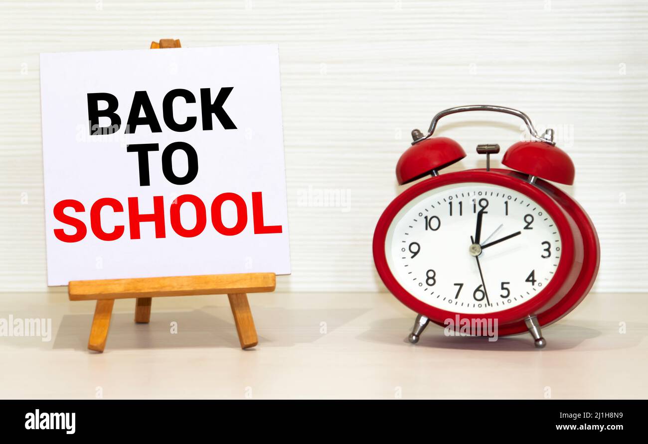 Alarm clock and school supplies on blue background. Back to school ...