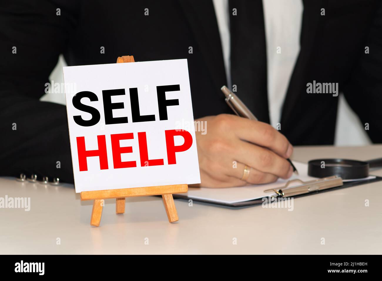 A hand holding 'Self-Help' book. business concept Stock Photo - Alamy