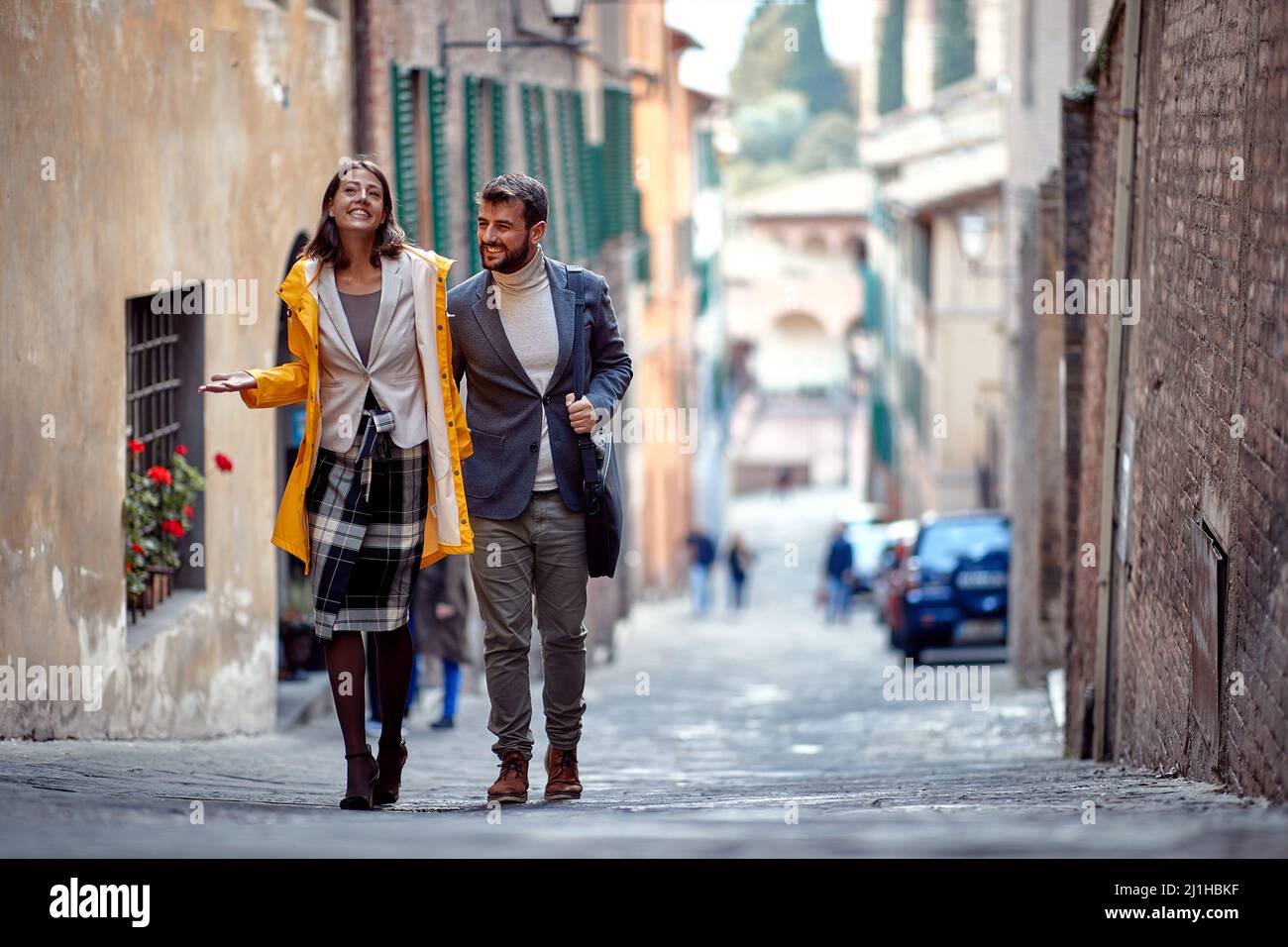 A young satisfied couple is walking the old city and chatting in ...