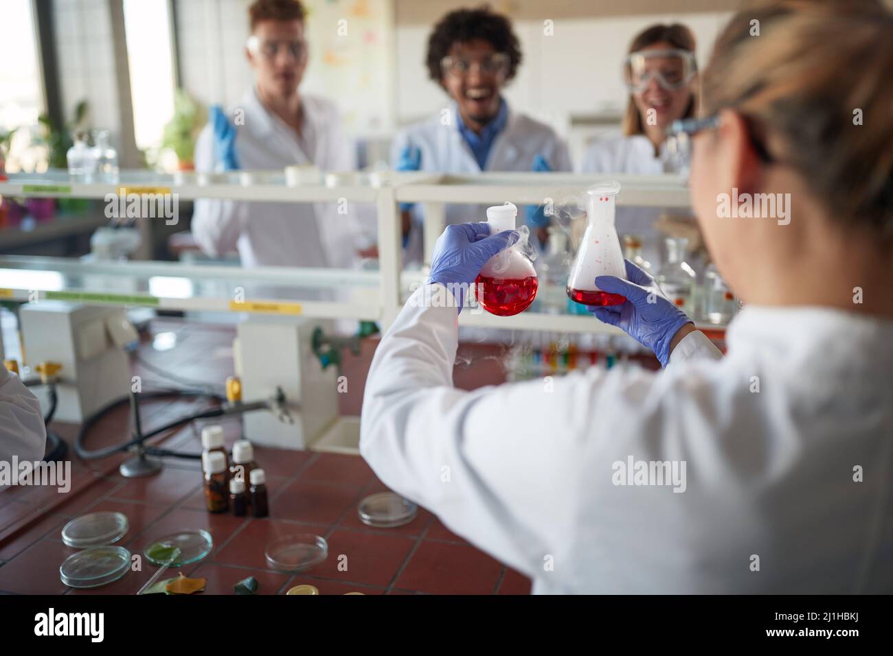 Young chemistry students are amazed by chemical reaction in an ...