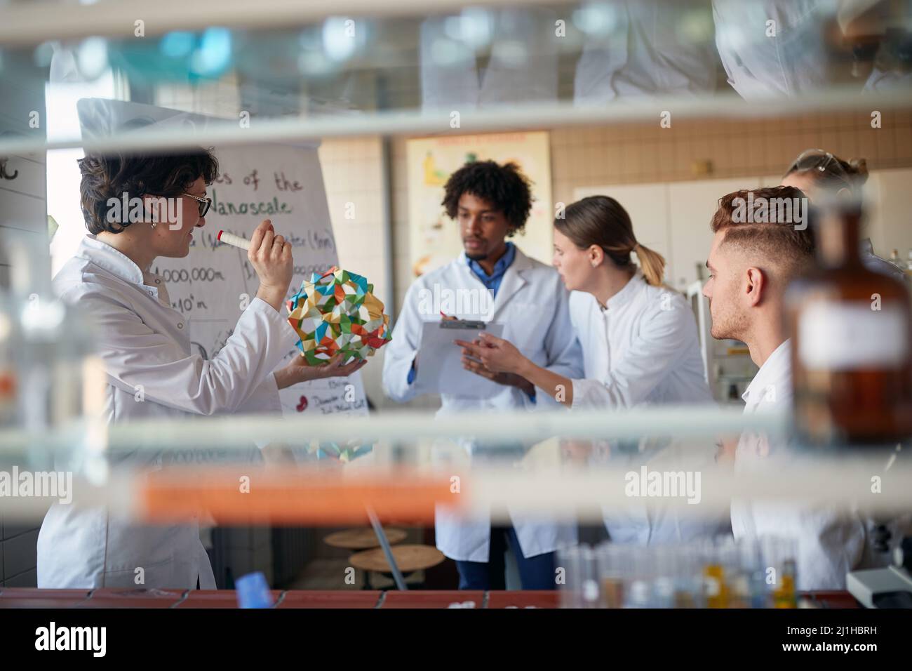 Young chemical students taking notes about lecture in the university ...