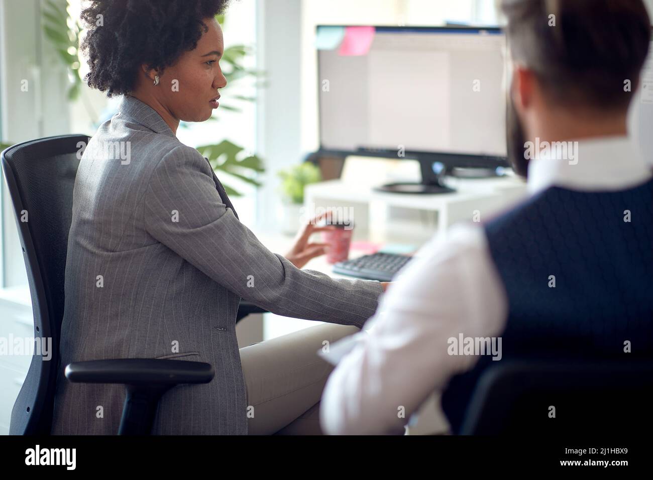 A young female employee is working at the desk in a working atmosphere ...
