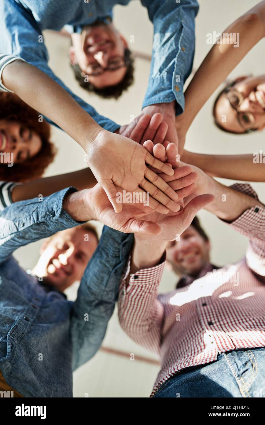 In it to succeed. Low angle portrait of a group of smiling coworkers in ...