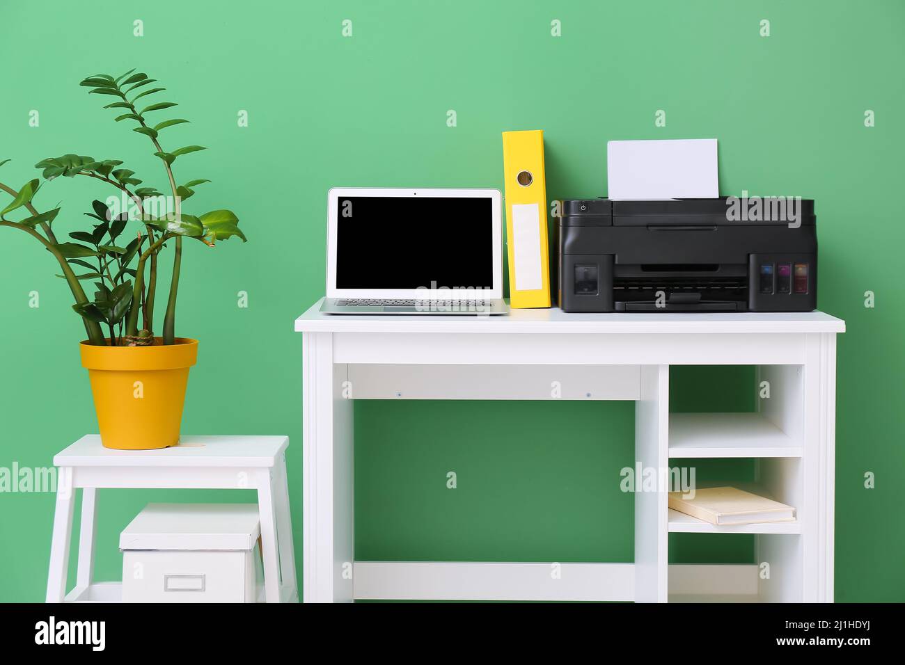 Workplace with modern laptop, printer and stepladder stool with ...