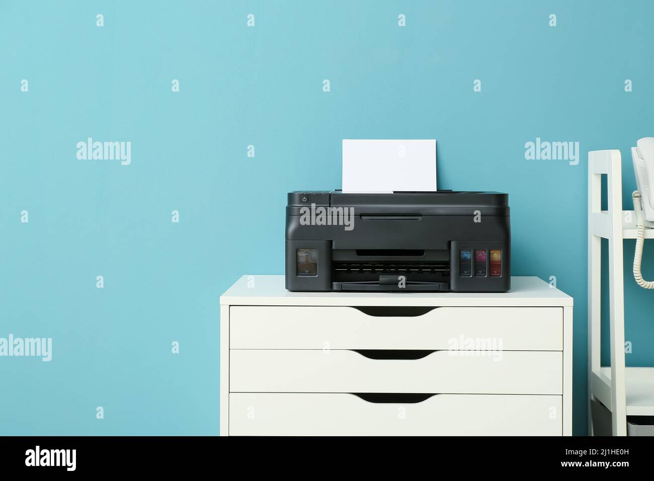 Chest of drawers with modern printer and shelf unit near color wall ...