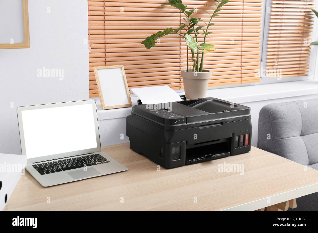 Modern laptop and printer on table in office Stock Photo - Alamy