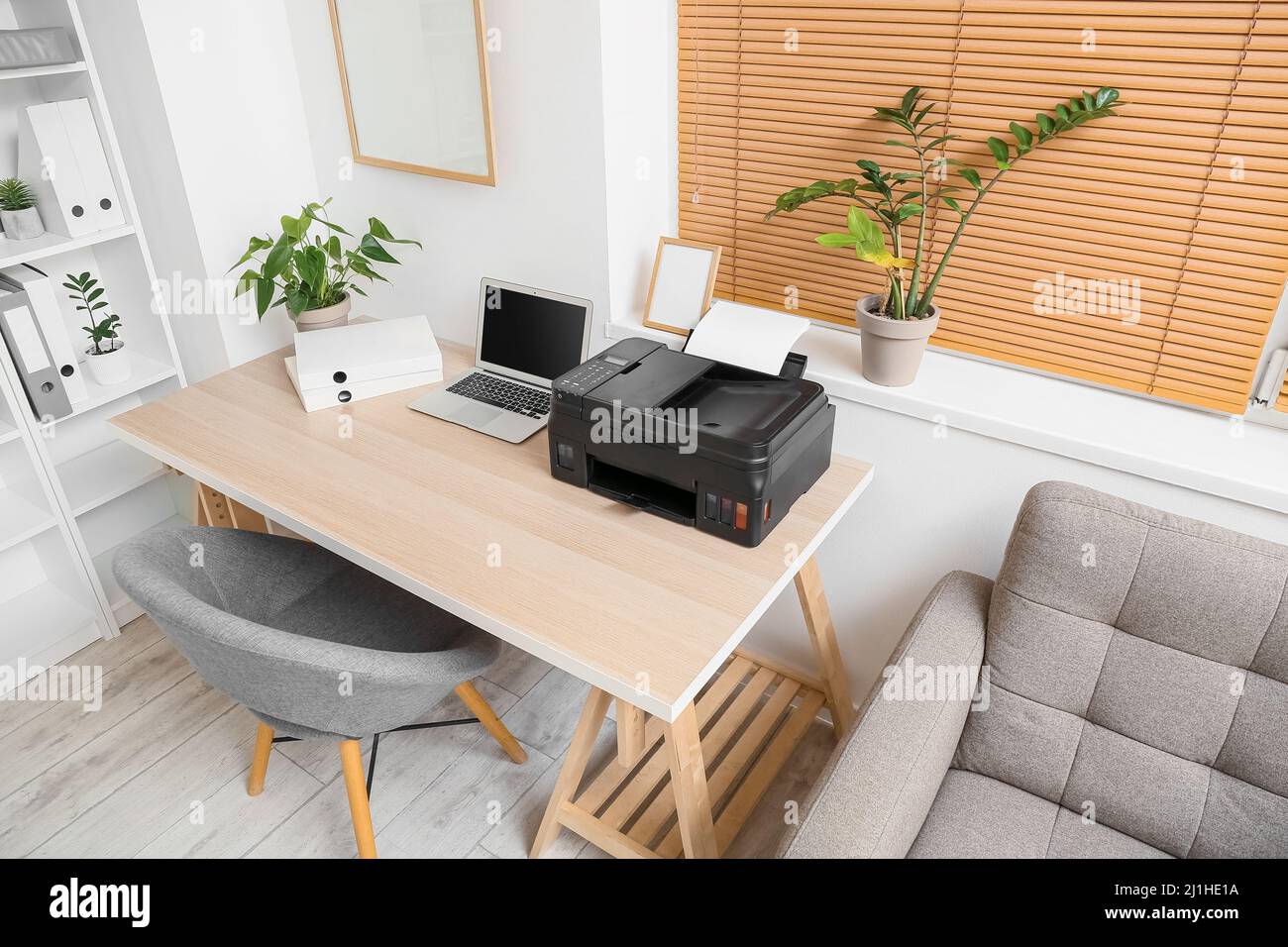 Modern printer and laptop on table in office interior Stock Photo - Alamy