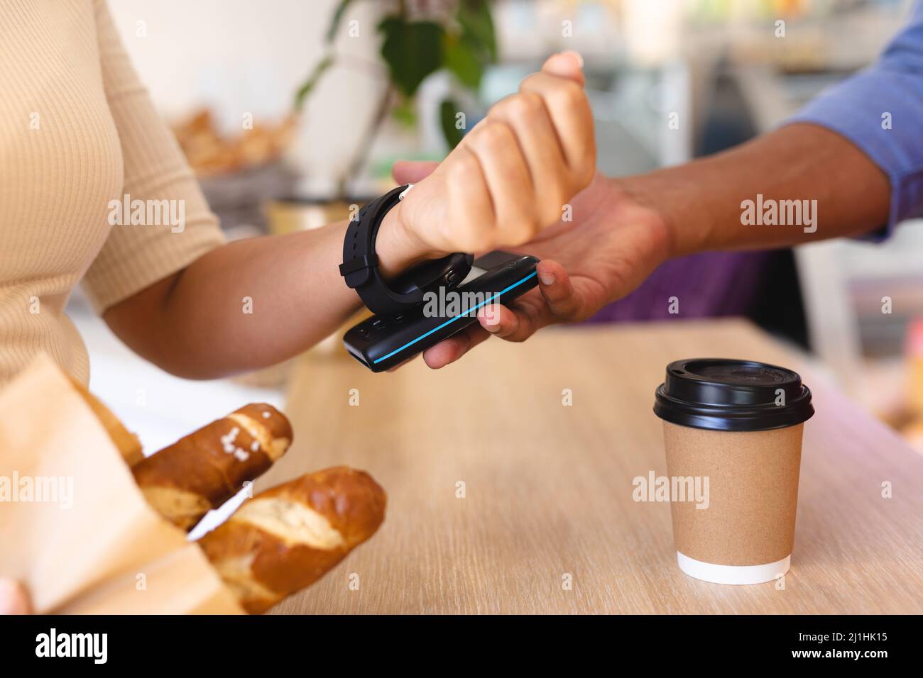 Female caucasian customer paying through digital wallet from smartwatch ...
