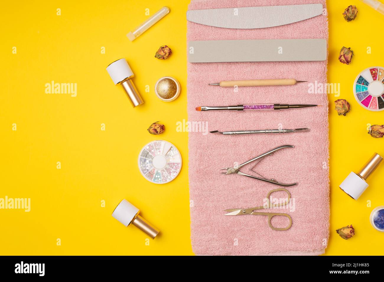 Manicure tools on a pink towel and a yellow background. Manicure ...