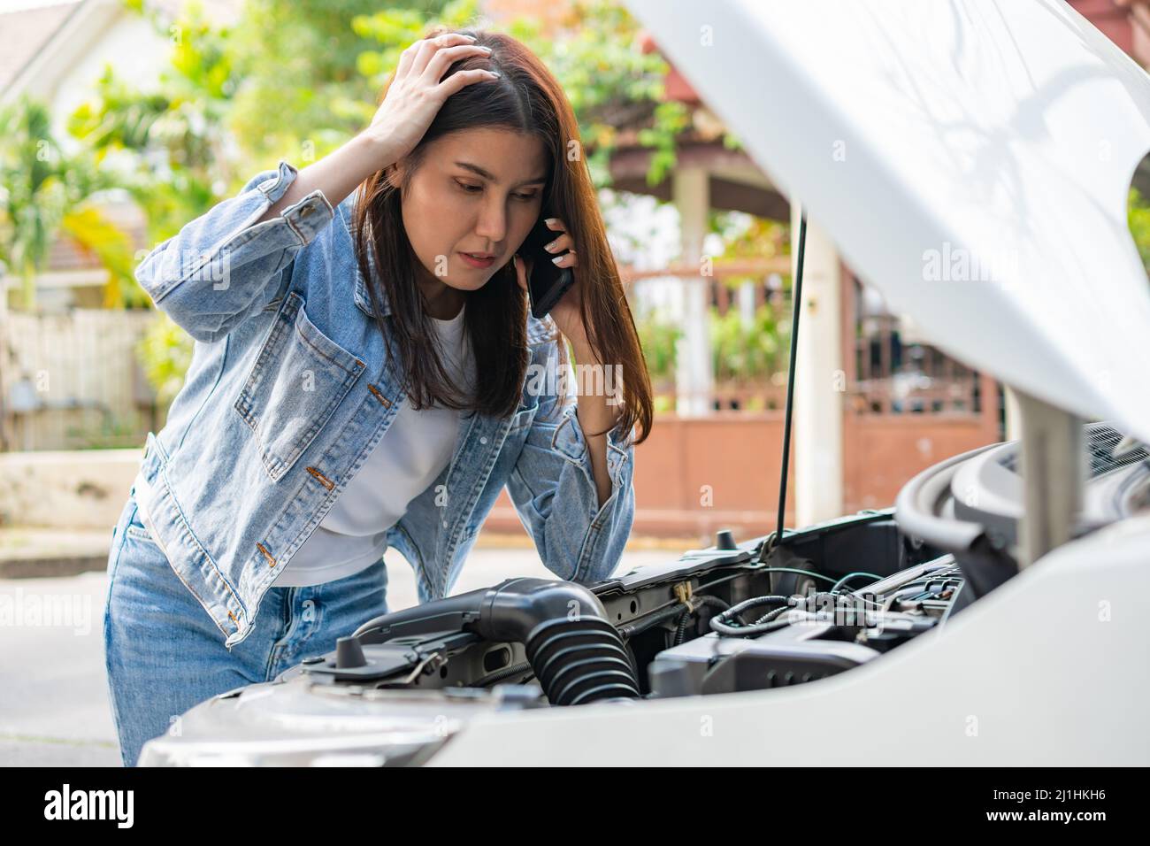 Angry Asian woman and using mobile phone calling for assistance after a ...