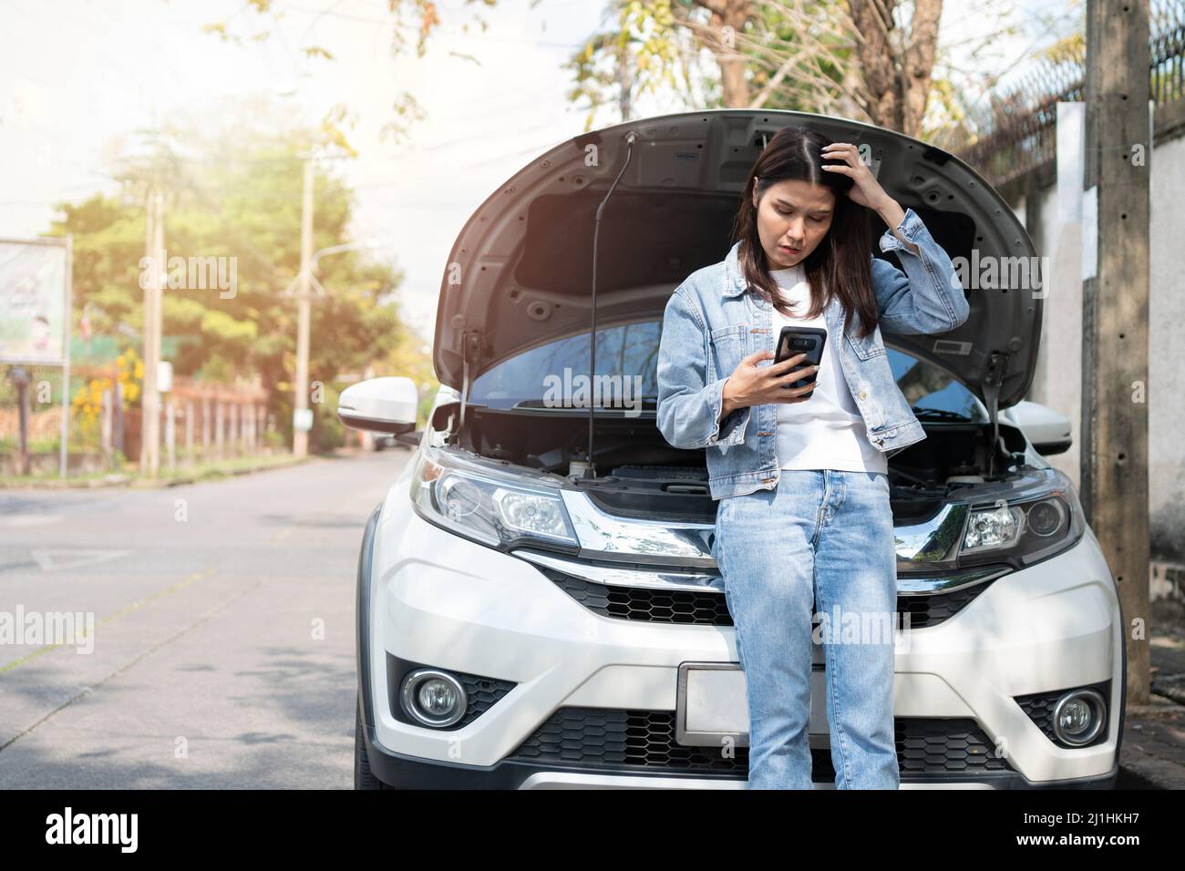Angry Asian woman and using mobile phone calling for assistance after a ...