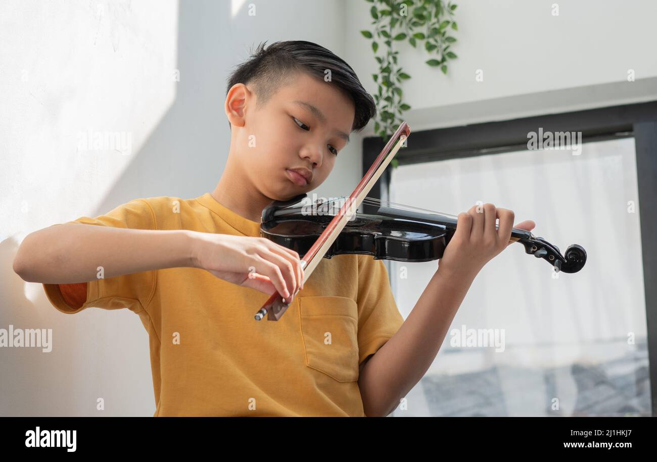 A Little Asian kid playing and practice violin musical string ...