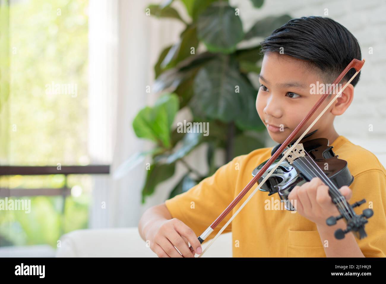 A Little Asian kid playing and practice violin musical string ...