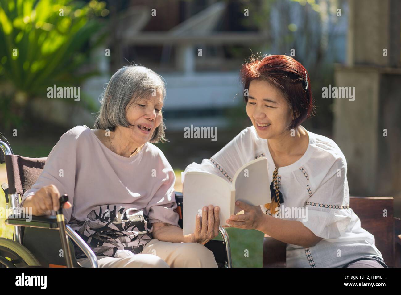 Elderly and daughter reading a book together for improves memory and ...