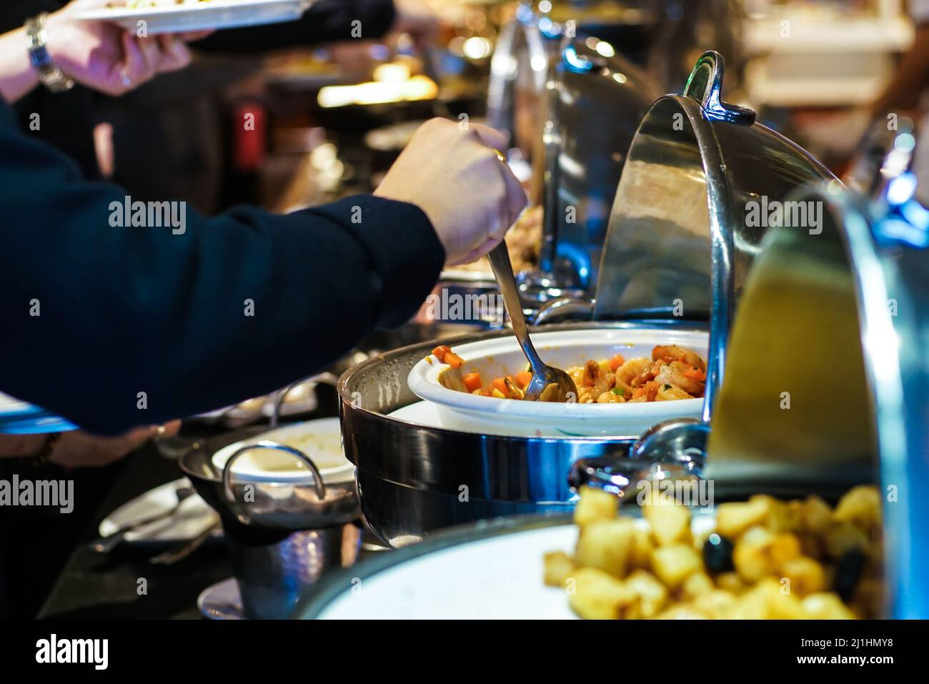 Group of people grab some buffet self service food on their own plate ...
