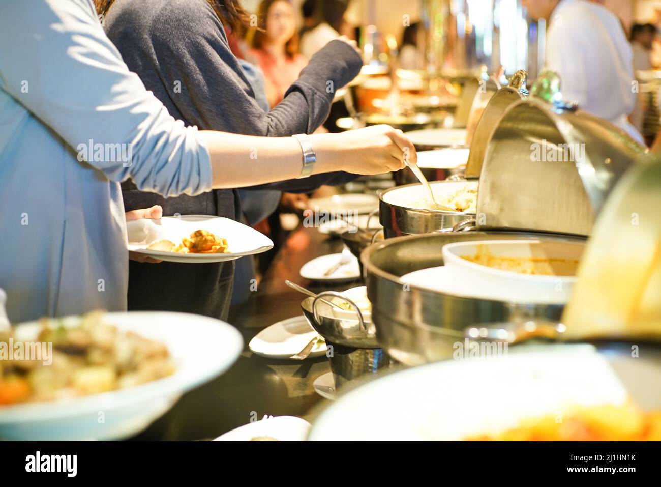Group of people grab some buffet self service food on their own plate ...