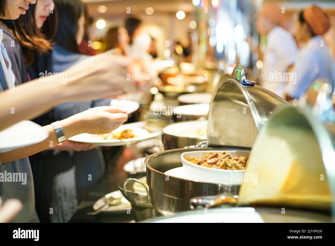 Group of people grab some buffet self service food on their own plate ...