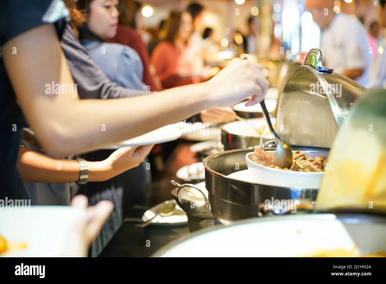 Group of people grab some buffet self service food on their own plate ...