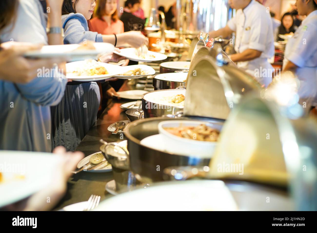Group of people grab some buffet self service food on their own plate ...