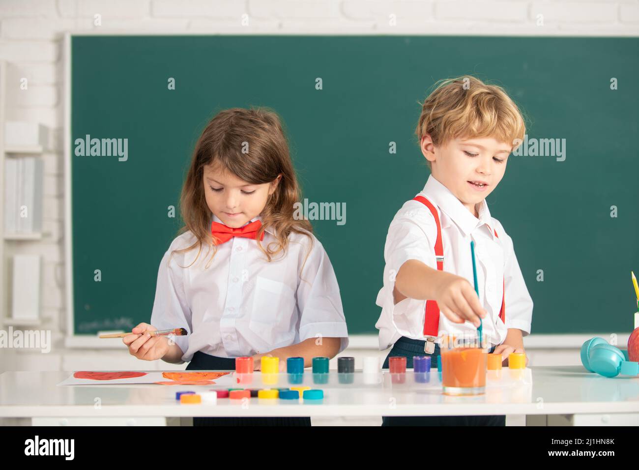 School children drawing a colorful pictures with pencil crayons in ...