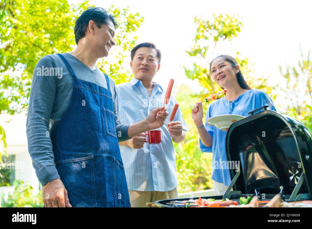 Happy seniors food meeting BBQ grilled party style in the garden Stock ...
