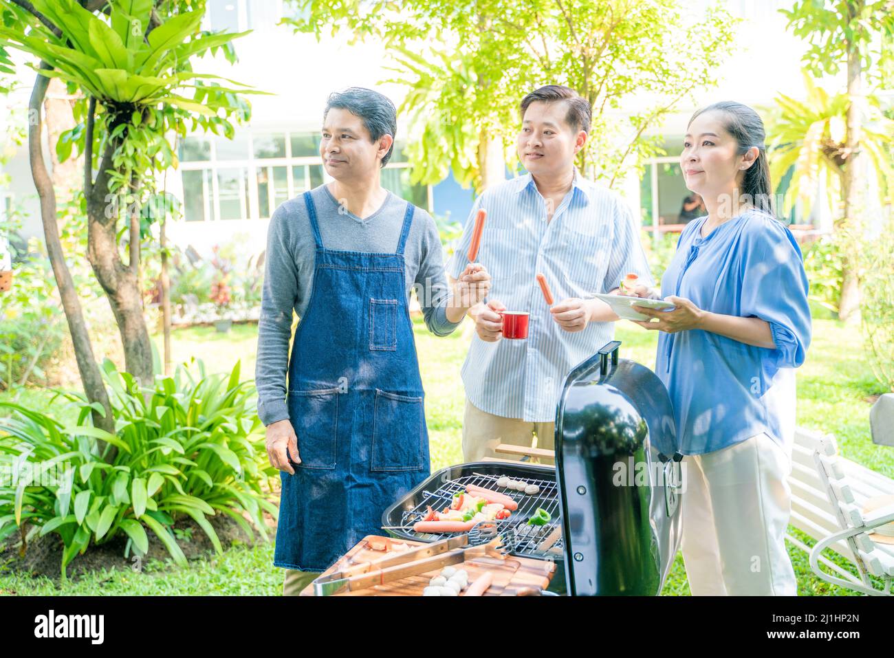 Happy seniors food meeting BBQ grilled party style in the garden Stock ...