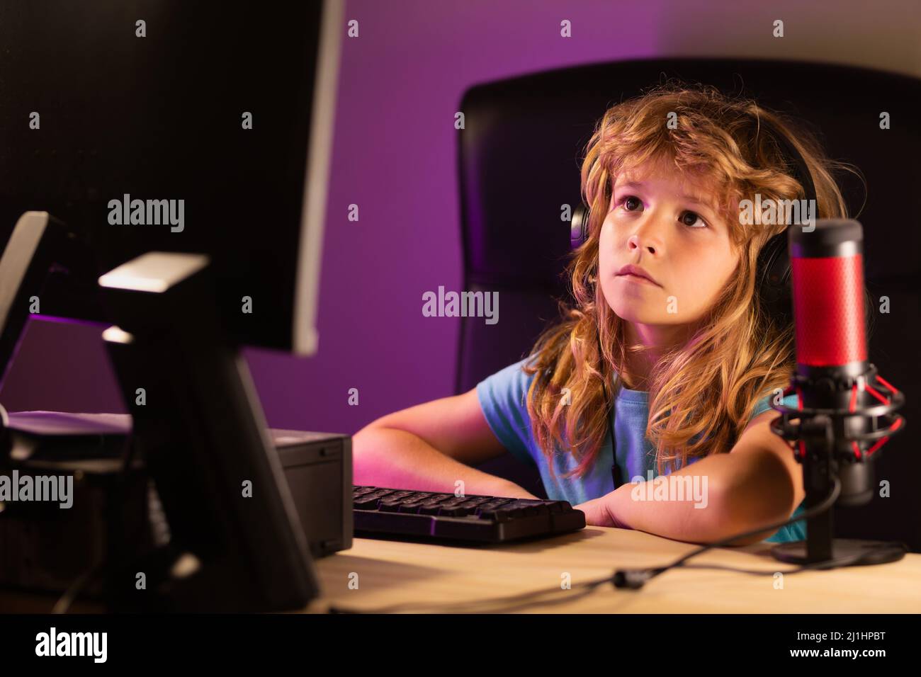 Little child gamer play computer game on desktop. Gaming stream and ...