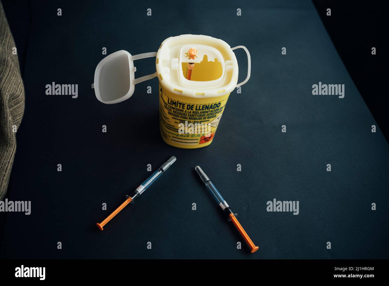 A person throwing a syringe into a medical waste container Stock Photo ...