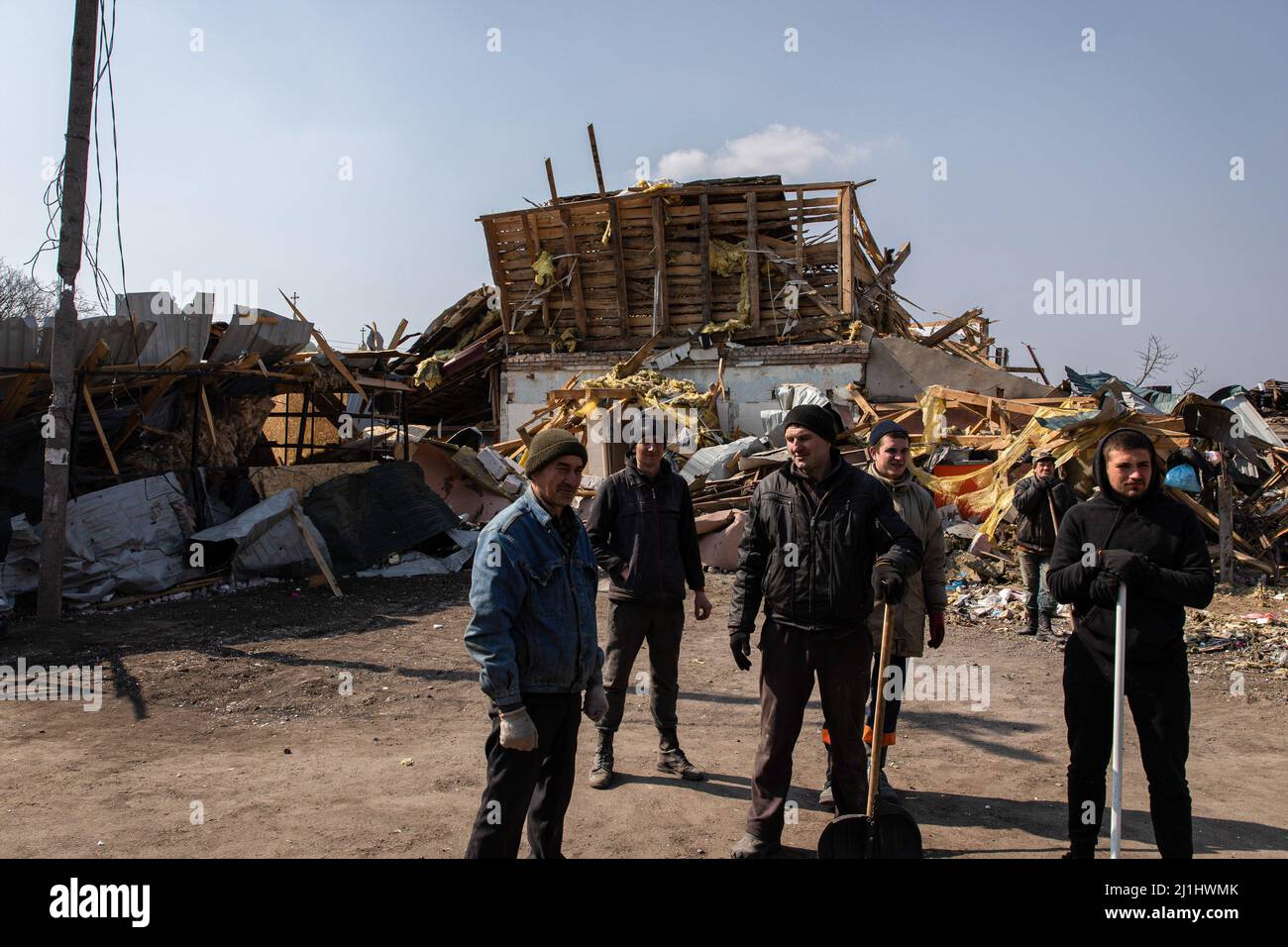 Kyiv, Ukraine. 25th Mar, 2022. Men preparing to clear up the debris of ...