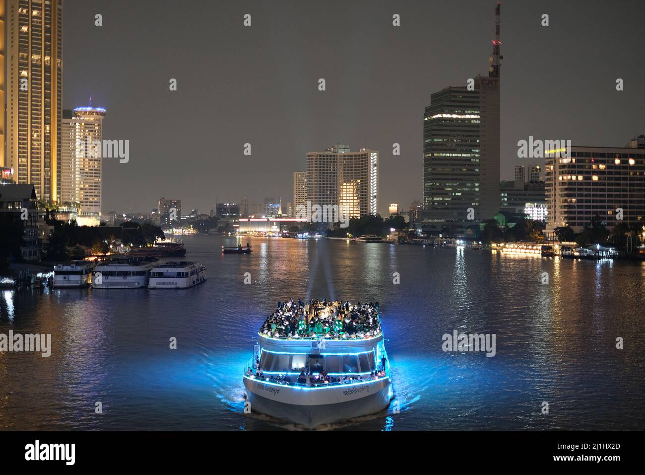 Dozens of people are having fun aboard of river-cruise ship, floating ...