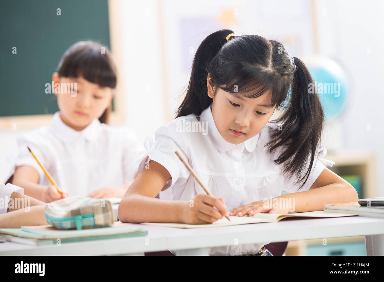 Elementary school students in the classroom learning Stock Photo - Alamy