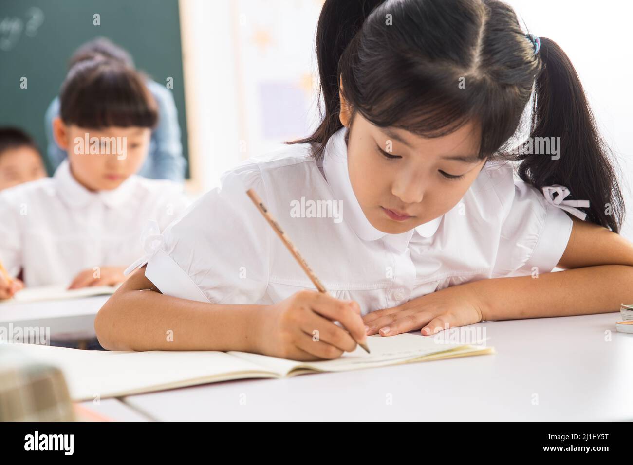 Elementary school students in the classroom learning Stock Photo - Alamy
