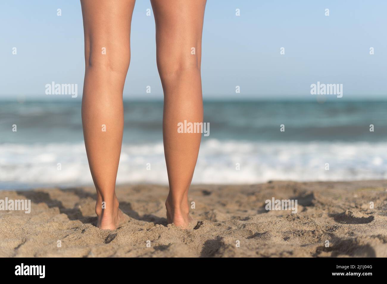 Female barefoot legs on sandy beach near waving sea Stock Photo - Alamy
