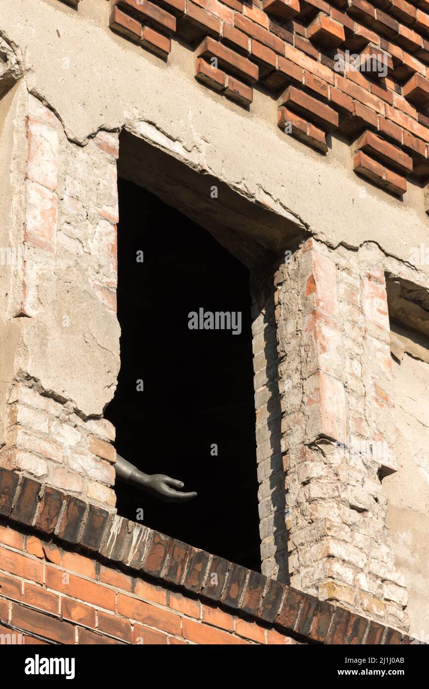 A hand is reached out of a broken window Stock Photo - Alamy